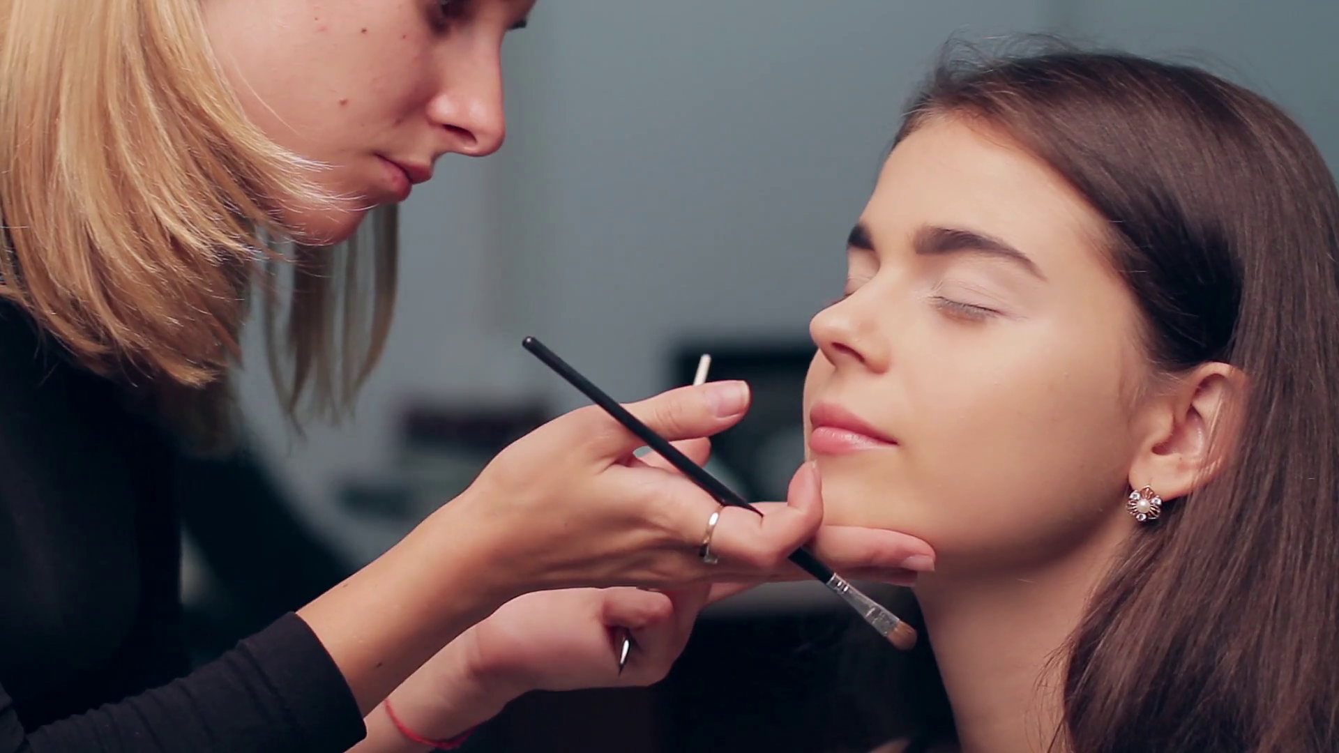 Specialist doing makeup for model. Gentle make-up for the young girl ...