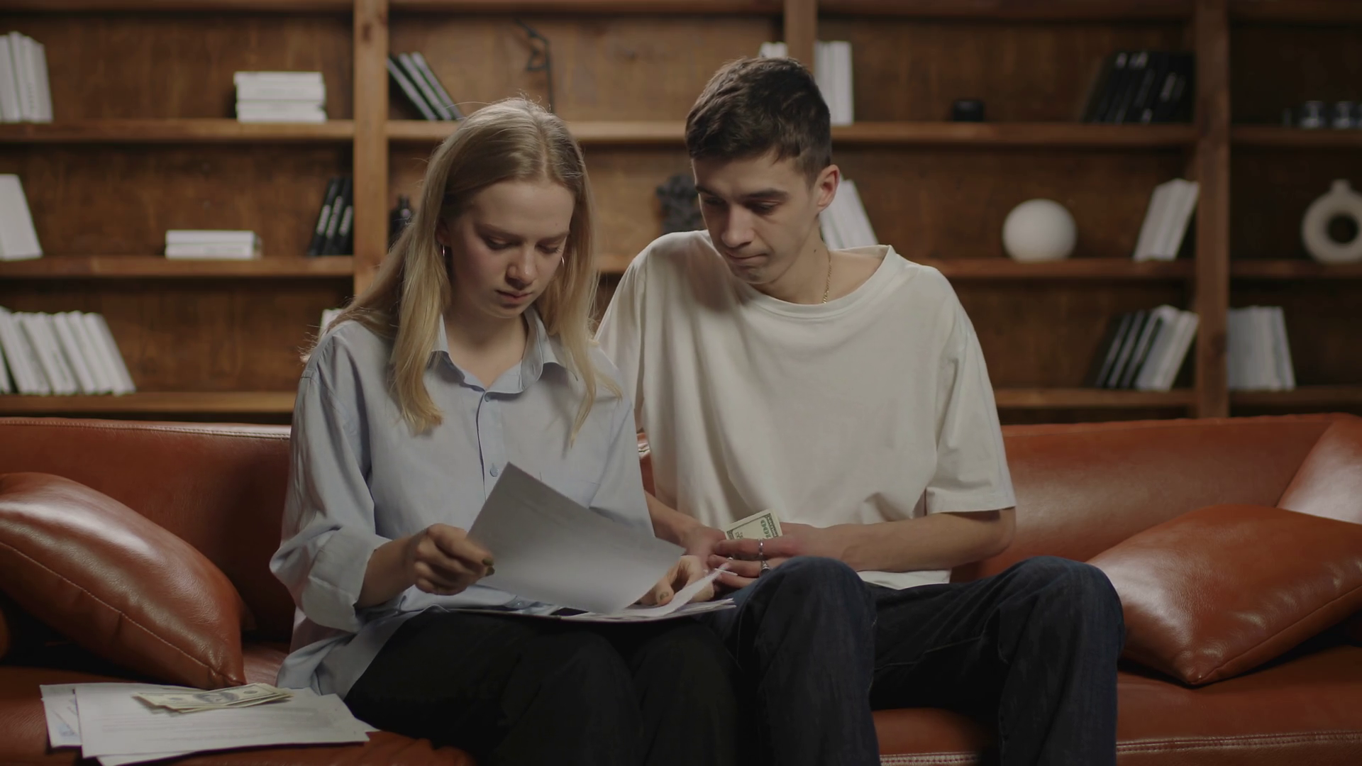 Young couple looking through paper bills and domestic documents ...