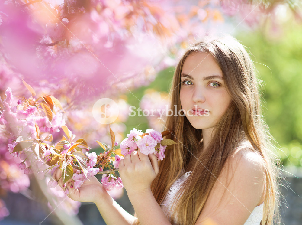 Lovely person in spring garden surrounded by blooming trees with pink ...