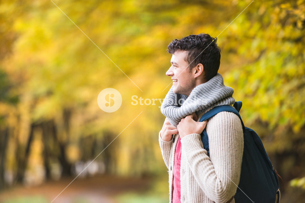 Handsome man with backback on a walk in colorful autumn forest Royalty ...