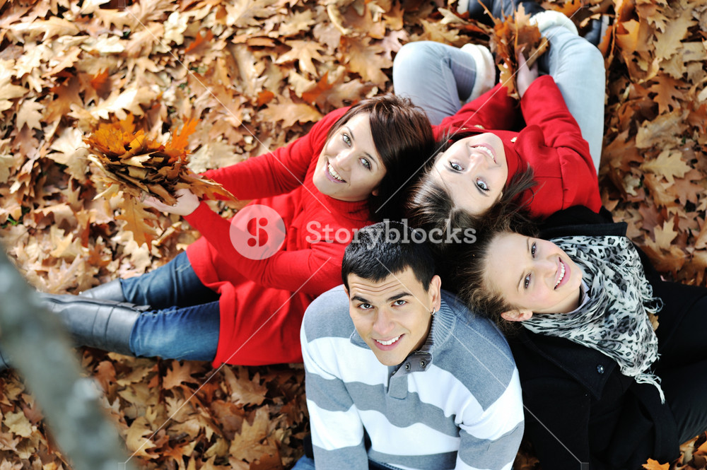 Joyful group of young friends enjoying autumn in the park Royalty-Free ...